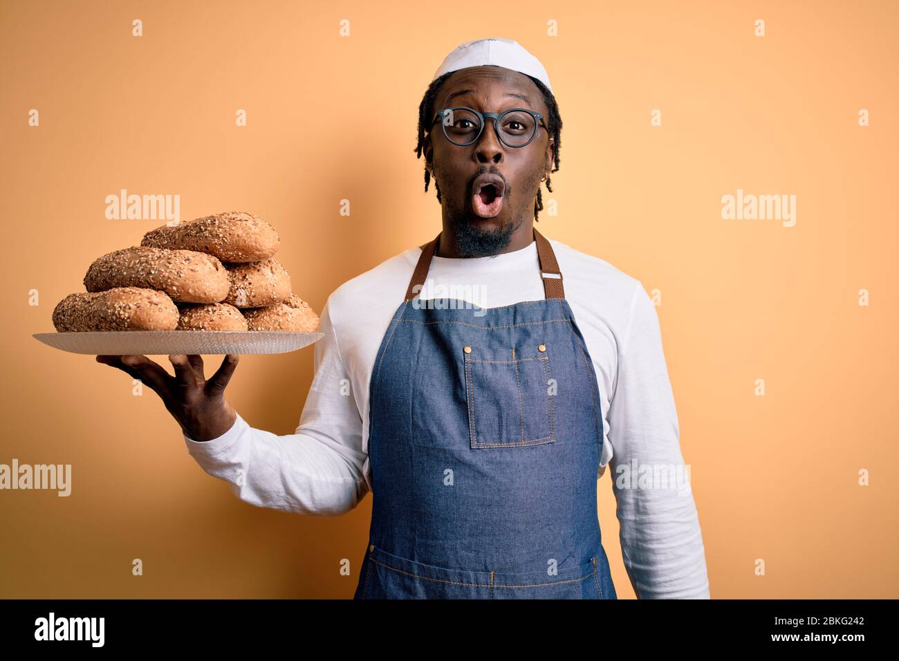 Young african american bakery man holding tray with healthy wholemeal ...