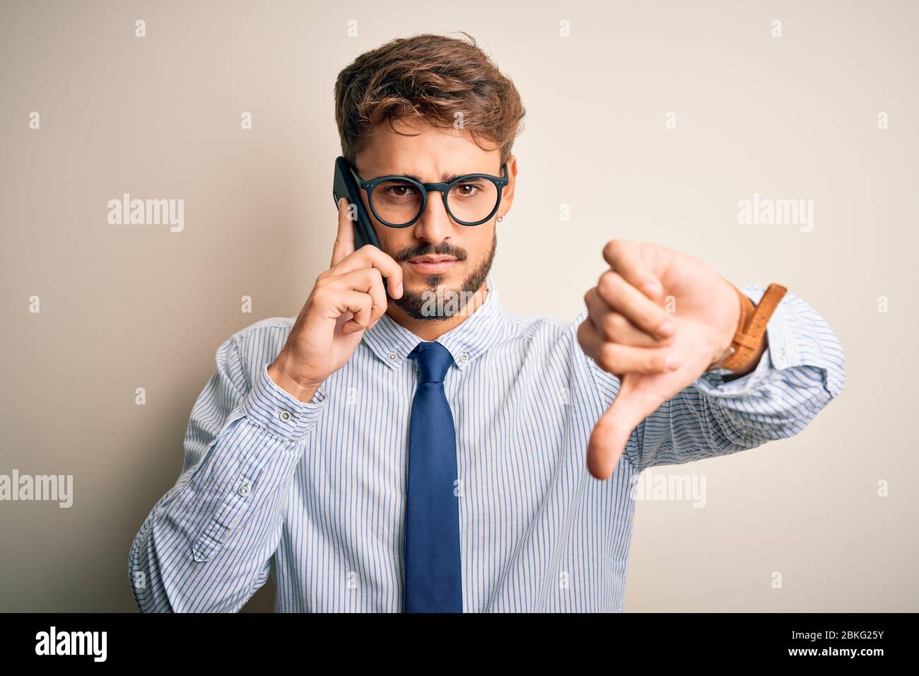 Young businessman having a conversation talking by smartphone over ...
