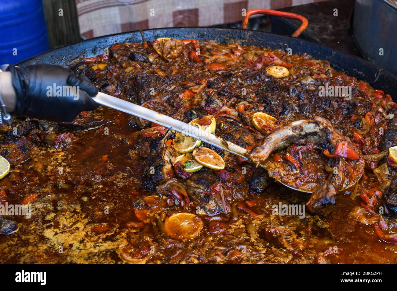 Traditional fish stew being prepared in a rustic bowl over a wood ...