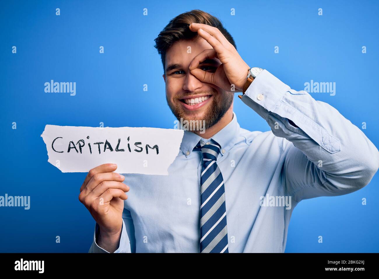 Young blond businessman with beard and blue eyes holding paper with ...