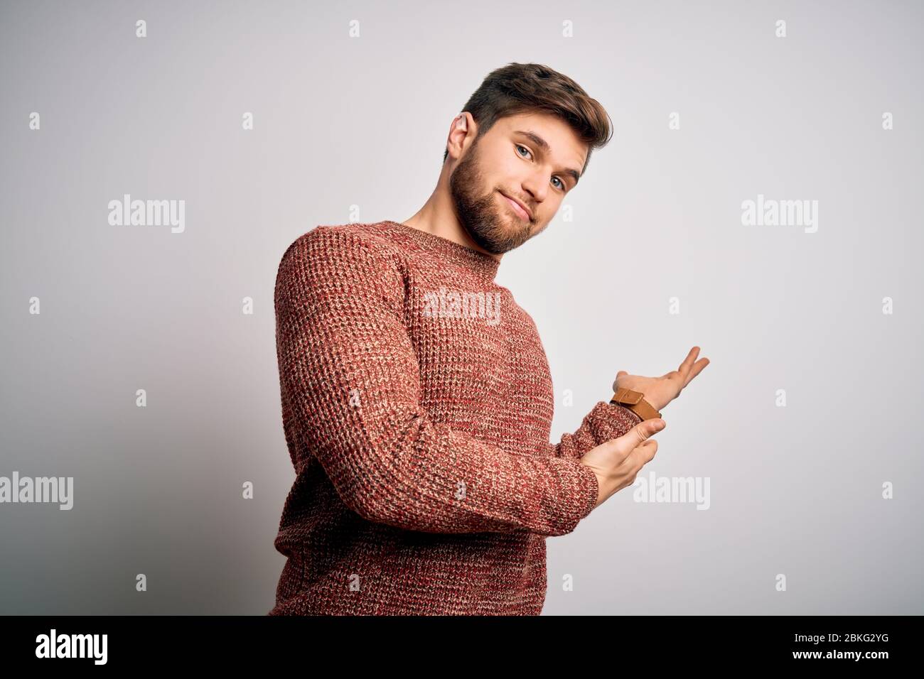 Young blond man with beard and blue eyes wearing casual sweater over ...