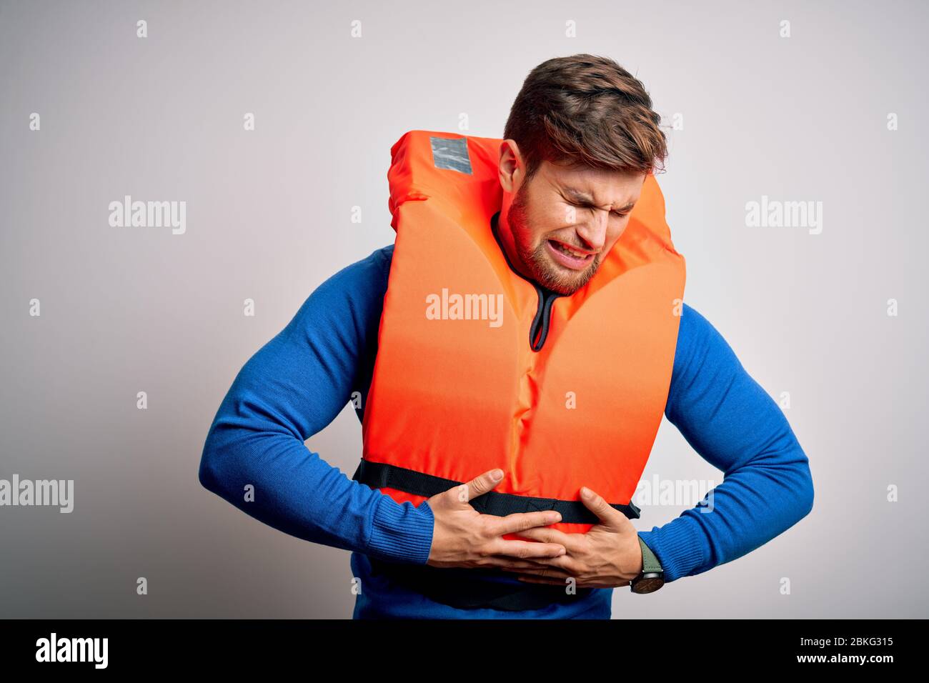 Young blond tourist man with beard and blue eyes wearing lifejacket ...