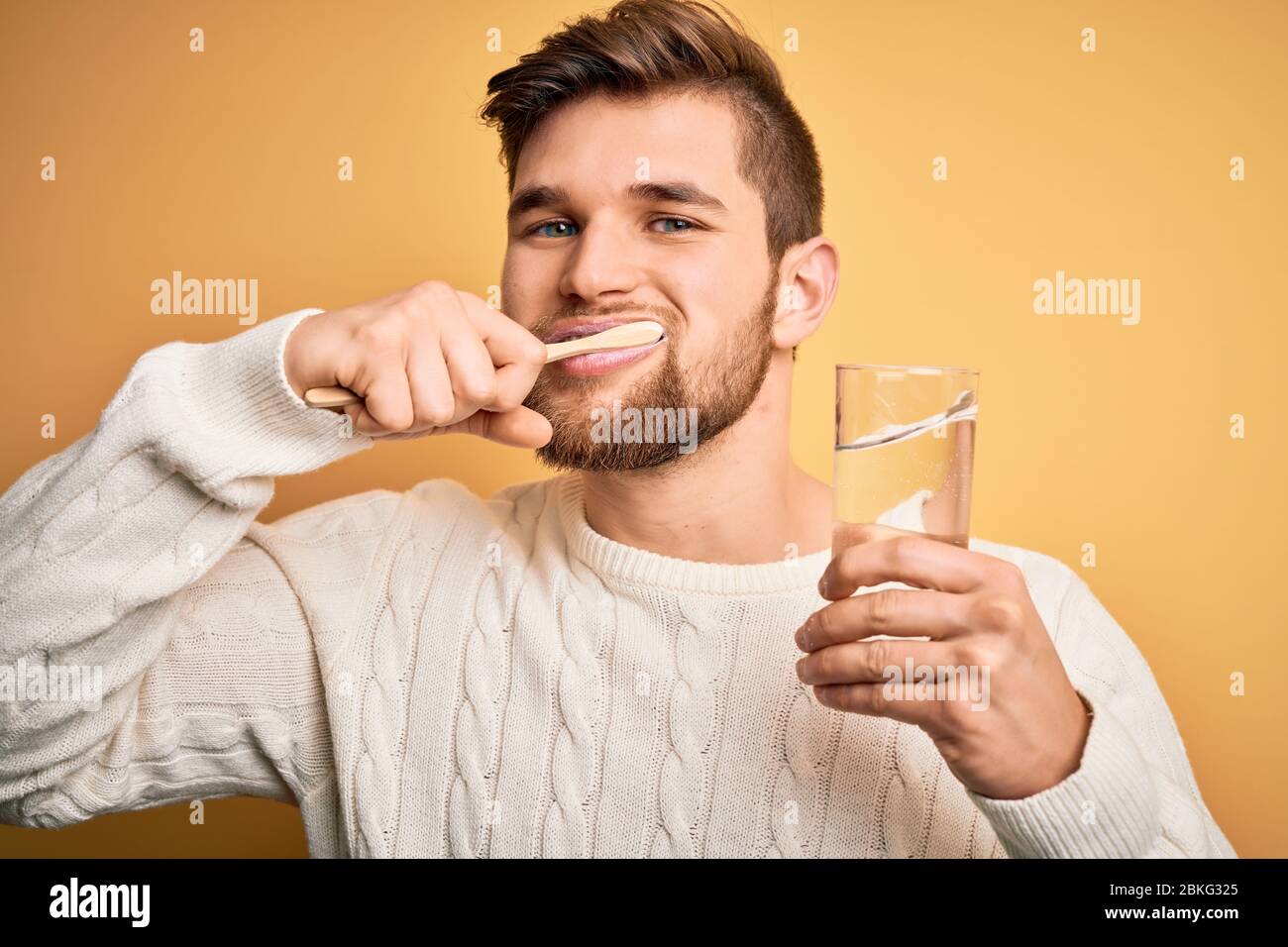 Young handsome caucasian man brushing his teeth using tooth brush, oral ...