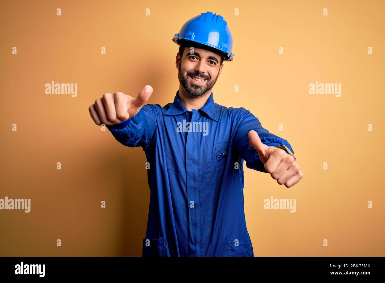 Mechanic man with beard wearing blue uniform and safety helmet over ...