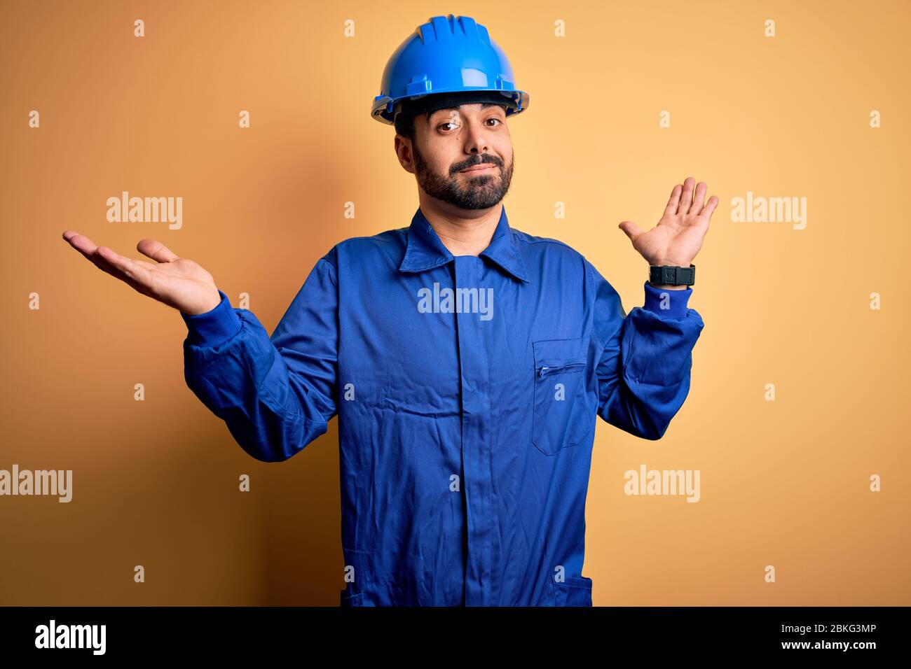Mechanic man with beard wearing blue uniform and safety helmet over ...