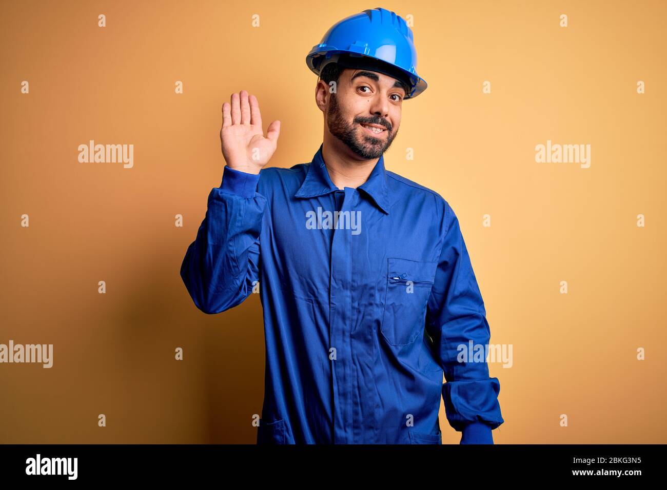 Mechanic man with beard wearing blue uniform and safety helmet over ...