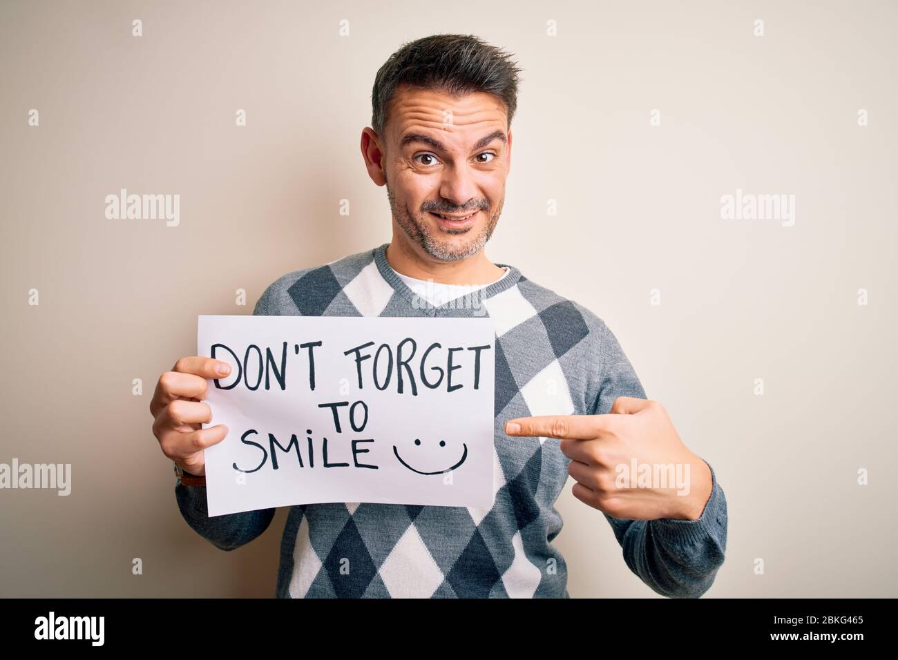 Young handsome man holding banner with funny positive message over ...