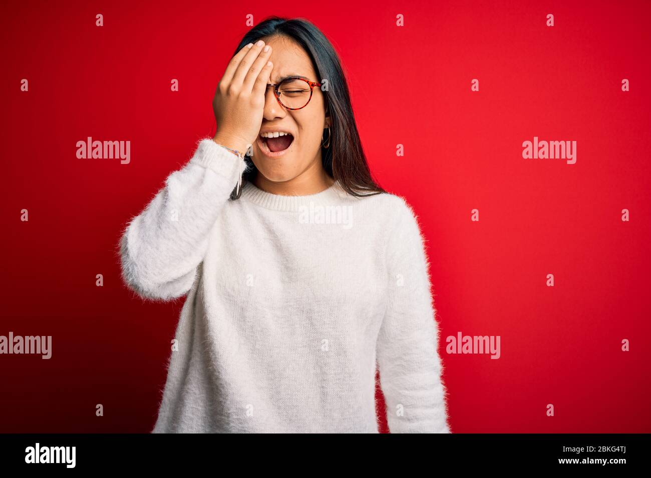 Young beautiful asian woman wearing casual sweater and glasses over red ...
