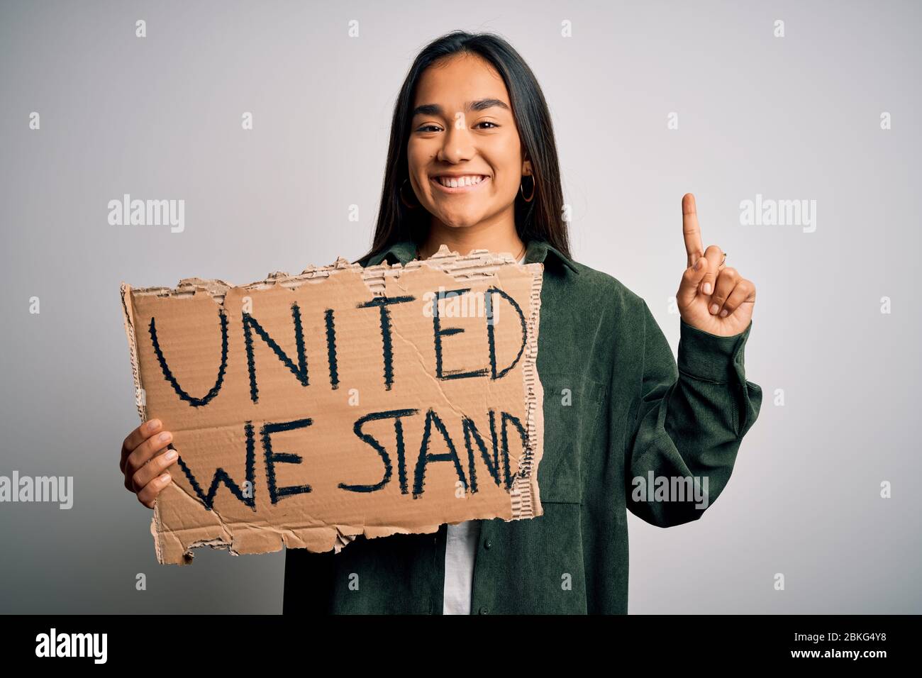 Young beautiful activist asian woman asking unity holding banner with ...