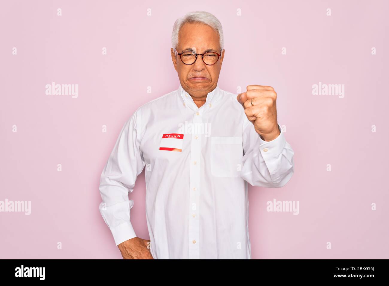 Middle age senior grey-haired man wearing hello my name is introduction ...
