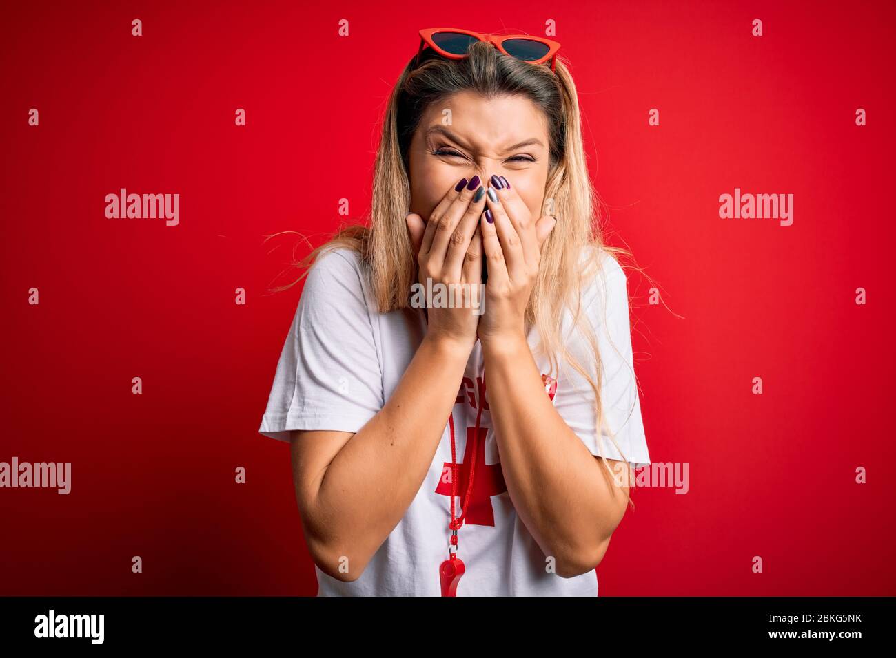 Young beautiful blonde lifeguard woman wearing t-shirt with red cross ...
