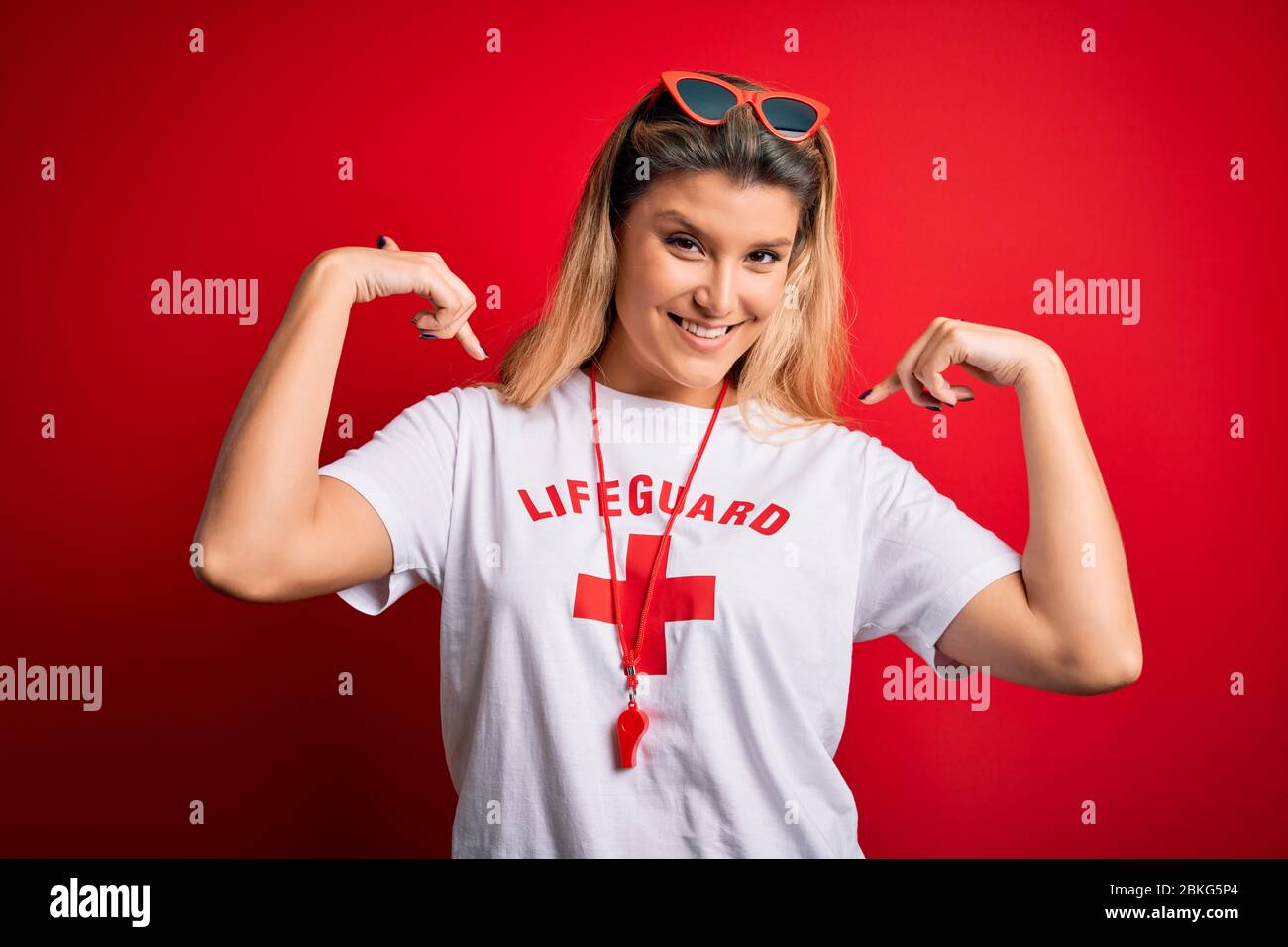 Young beautiful blonde lifeguard woman wearing t-shirt with red cross ...