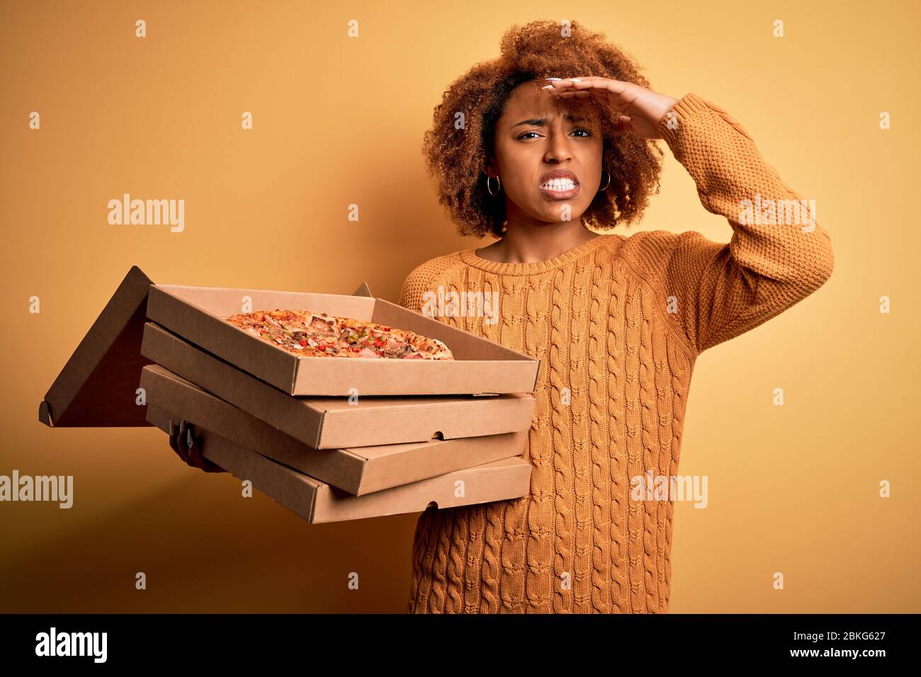 Young African American afro woman with curly hair holding delivery ...