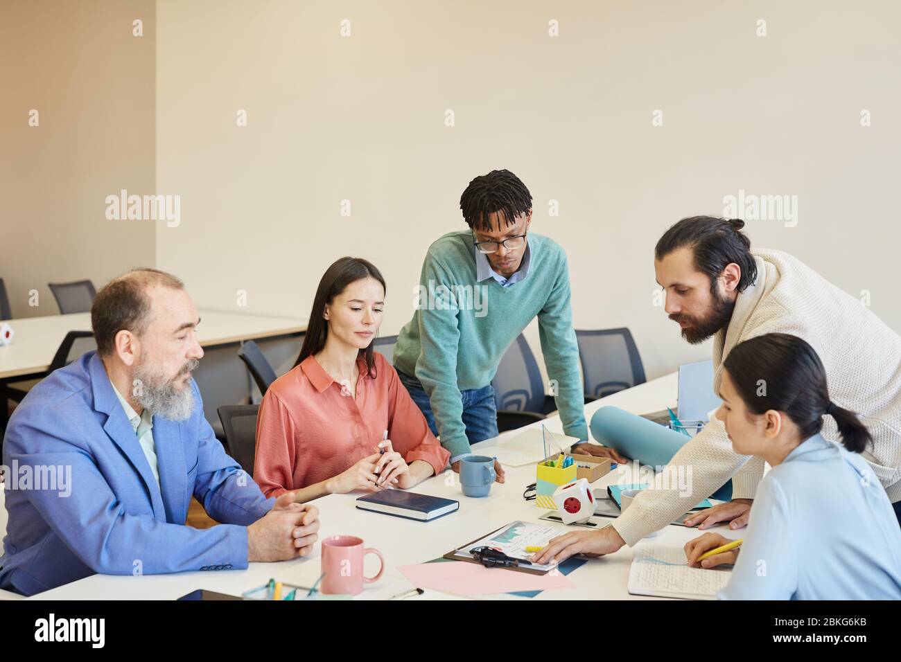 Group of five business people working together on new project having ...