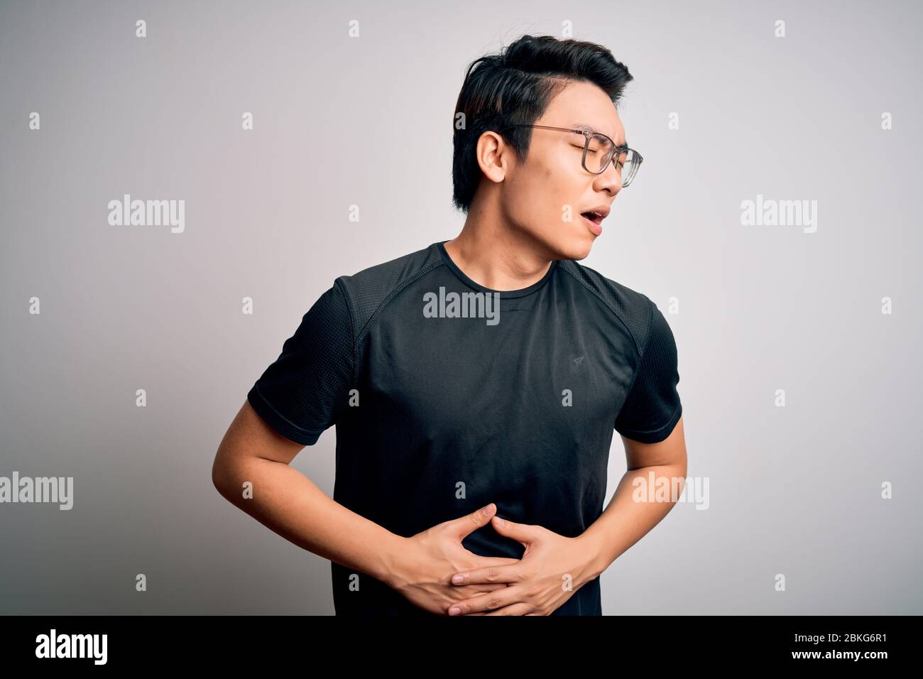 Young handsome chinese man wearing black t-shirt and glasses over white ...