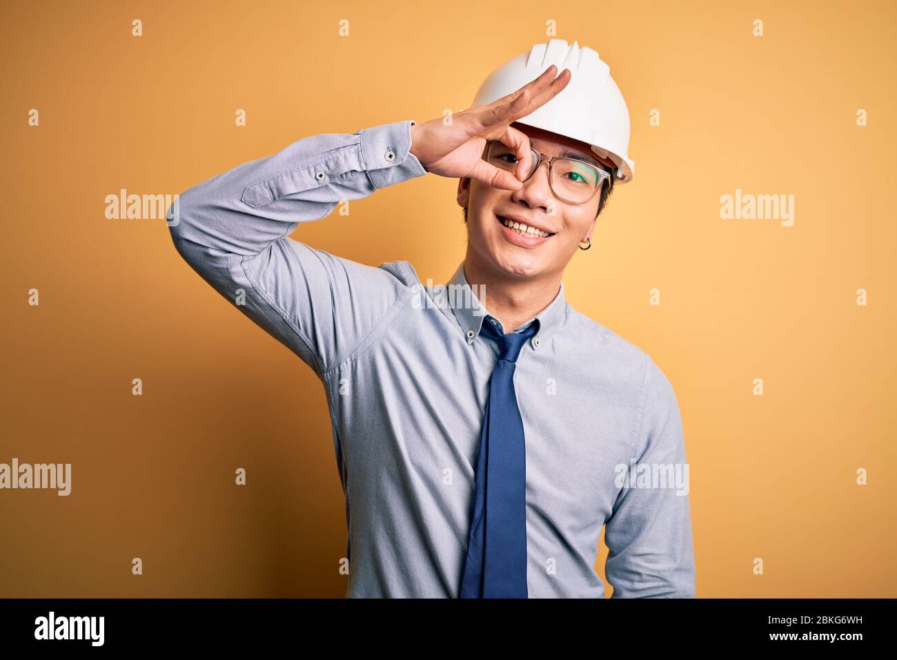 Young handsome chinese architect man wearing safety helmet and tie over ...