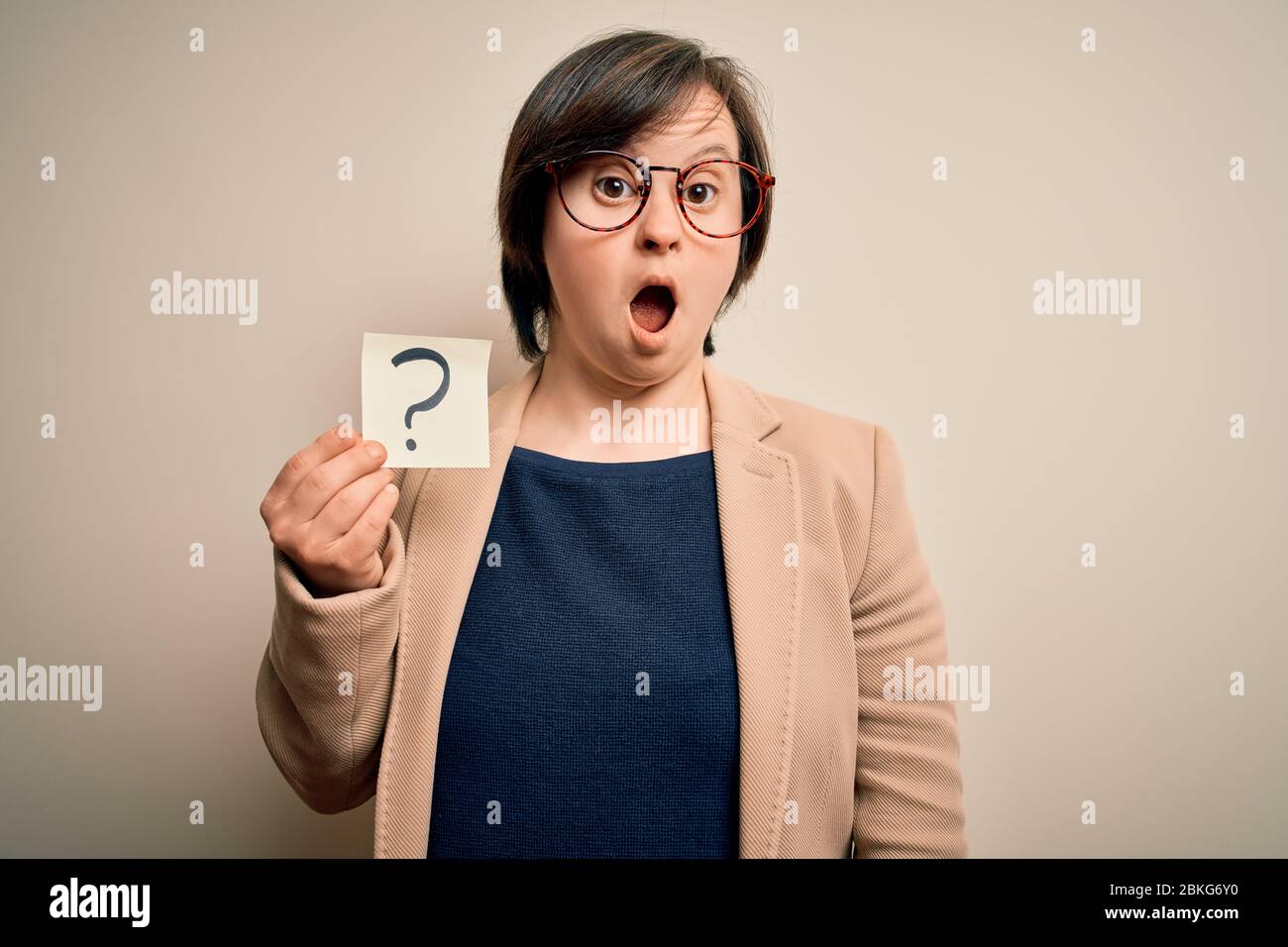 Young down syndrome business woman holding question mark paper as doubt ...