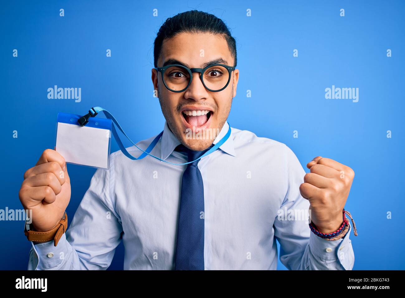 Young brazilian call center agent man holding id identification card ...
