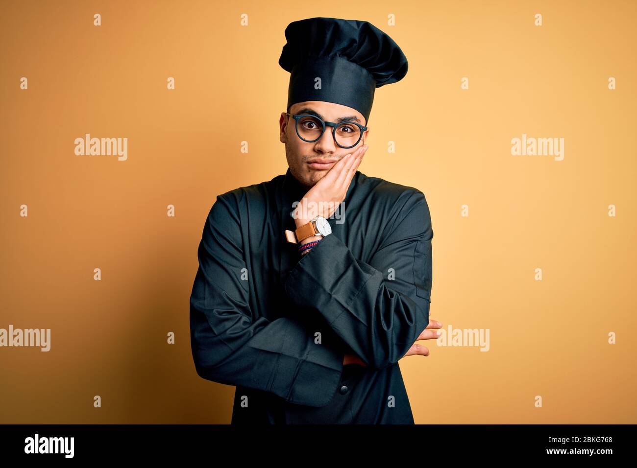 Young brazilian chef man wearing cooker uniform and hat over isolated ...