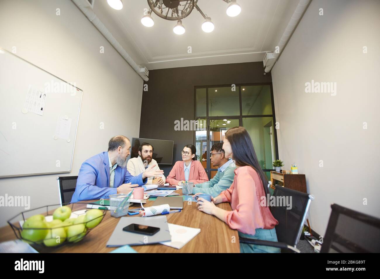 Group of stylish office workers sitting together in modern office board ...
