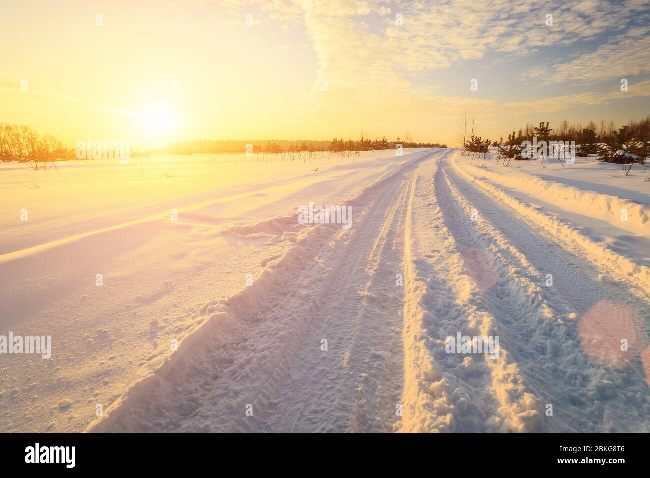 Countryside winter road on a sunset or sunrise with cloudy sky ...