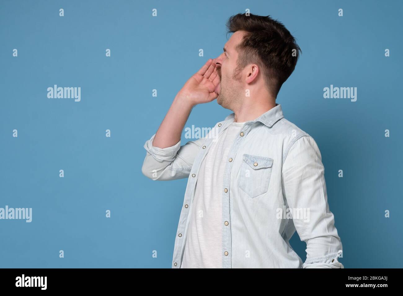 Caucasian handsome young man calling someone, isolated over blue ...