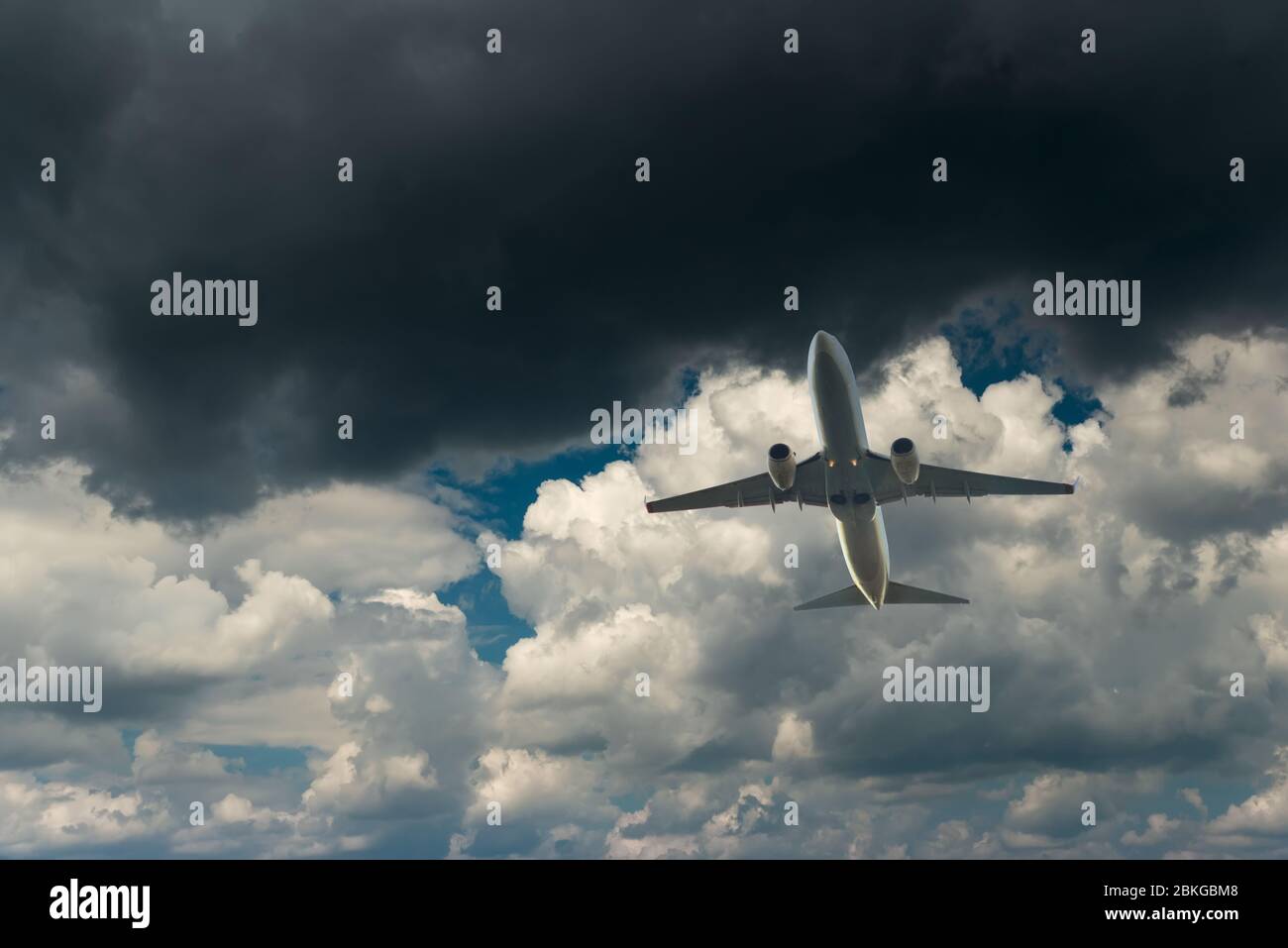 Commercial airplane flying through clouds in dramatic sky. Travel ...