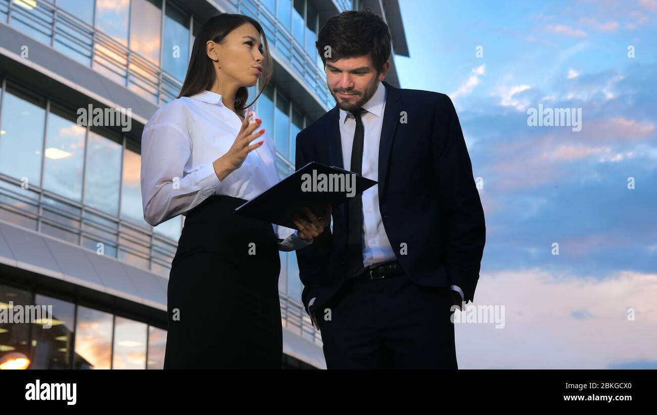 Elegant woman secretary showing documents to her boss giving bri Stock ...