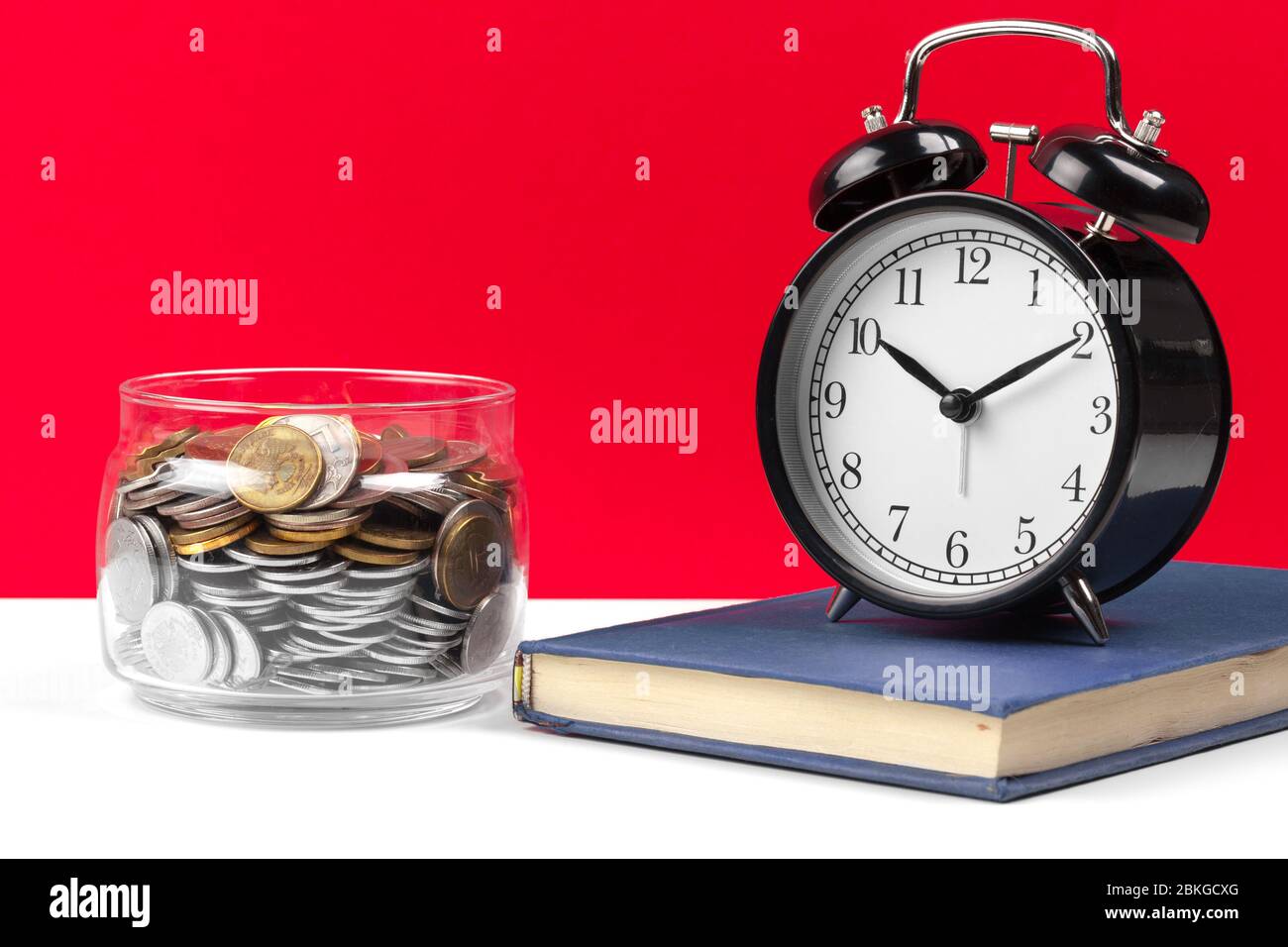 Alarm clock and money coins on the table Stock Photo - Alamy