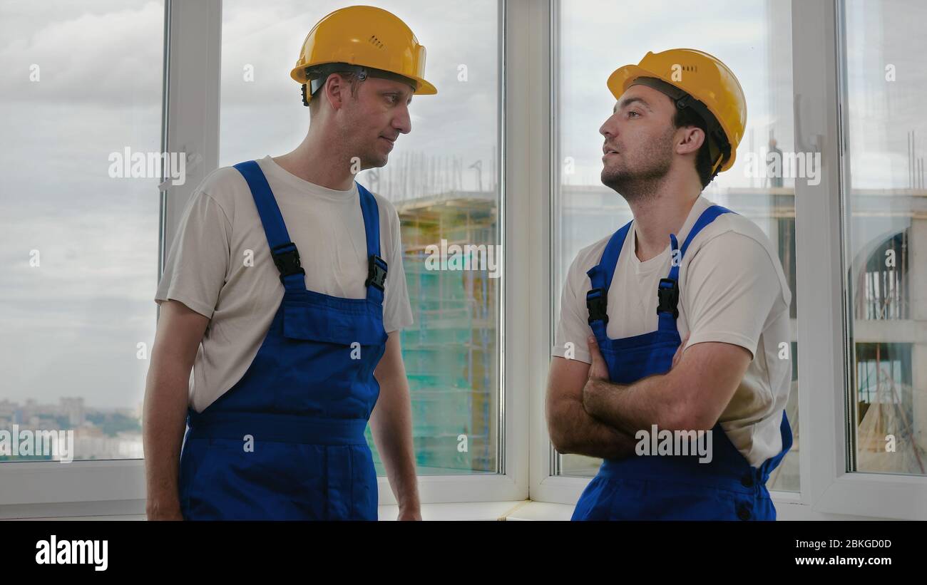 Construction workers having a talk Stock Photo - Alamy