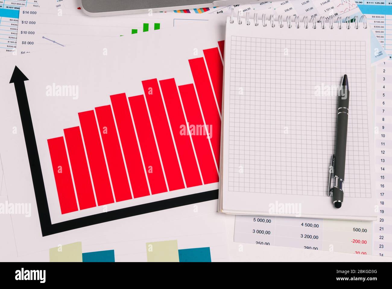 Business chart and an open blank Notepad with a pen. Profit chart ...