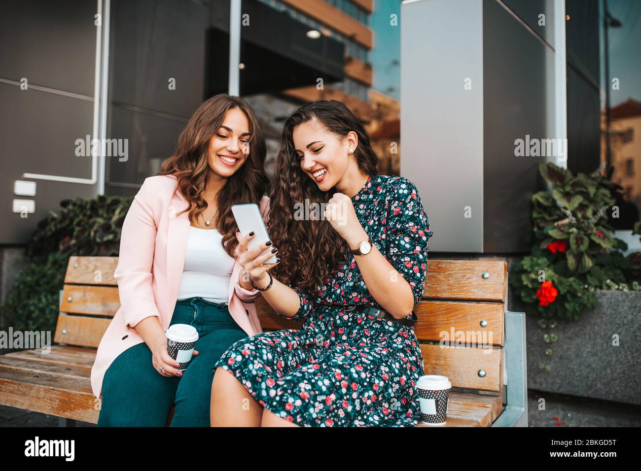 Two happy women friends celebrating success while reading good news on ...