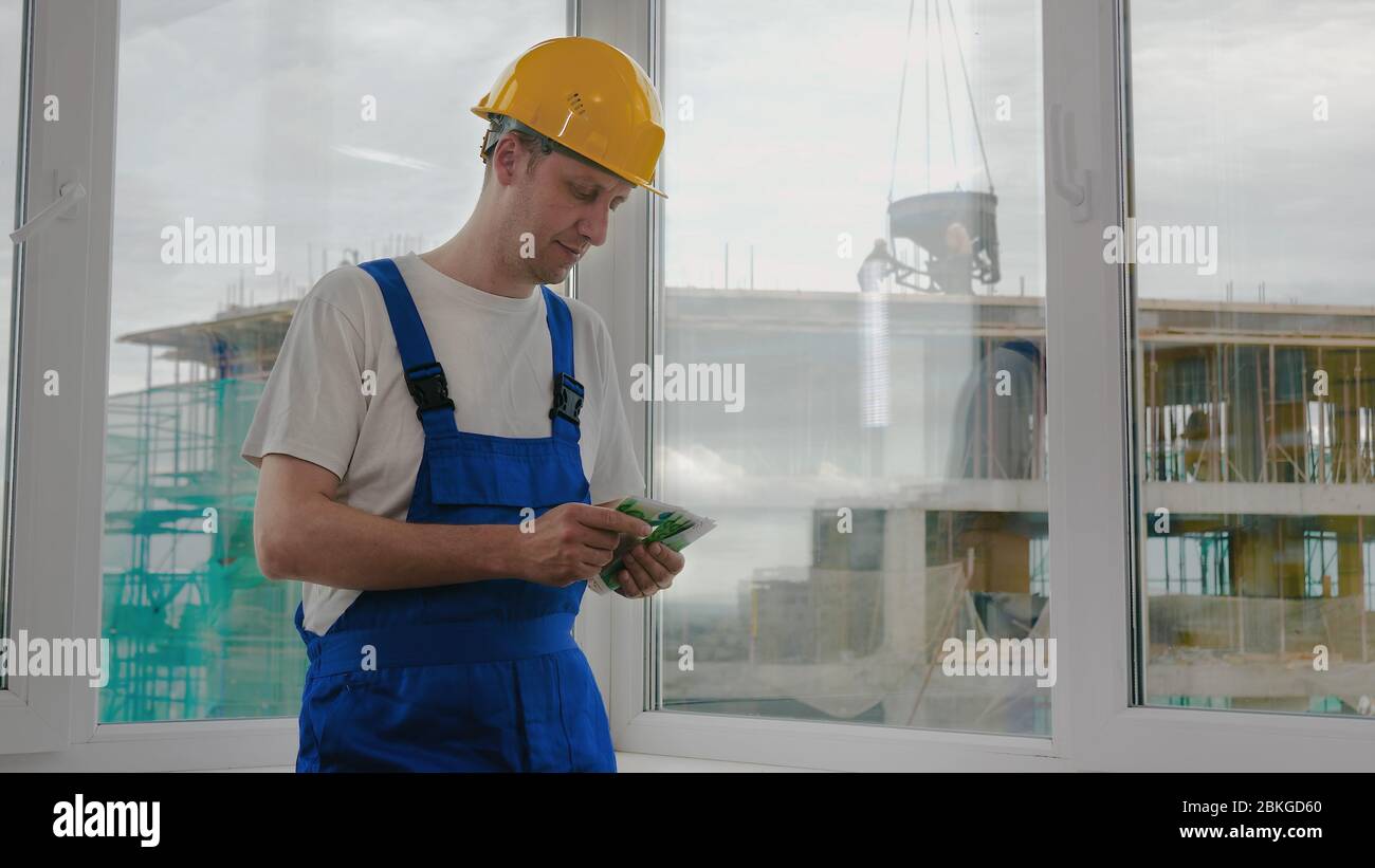 Construction worker counts the money Stock Photo - Alamy