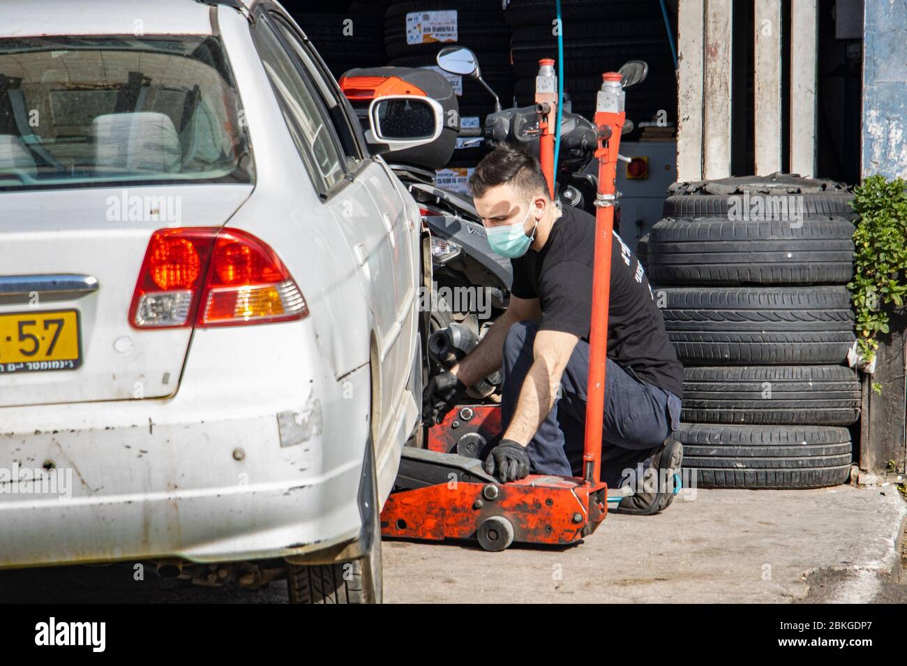 Jerusalem, Israel - April 21st, 2020: A worker at a tire repair shop ...