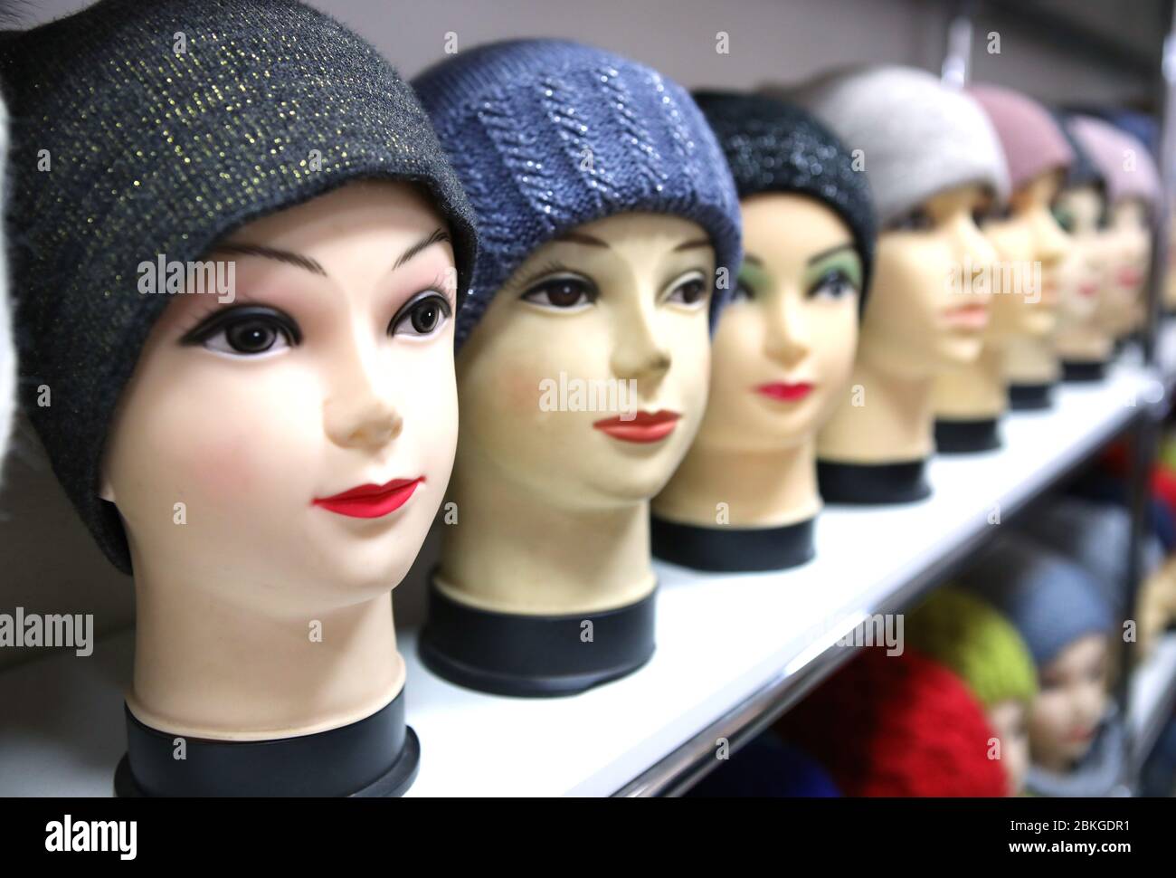 Mannequin heads in knitted hats and scarves. Mannequins female heads in ...
