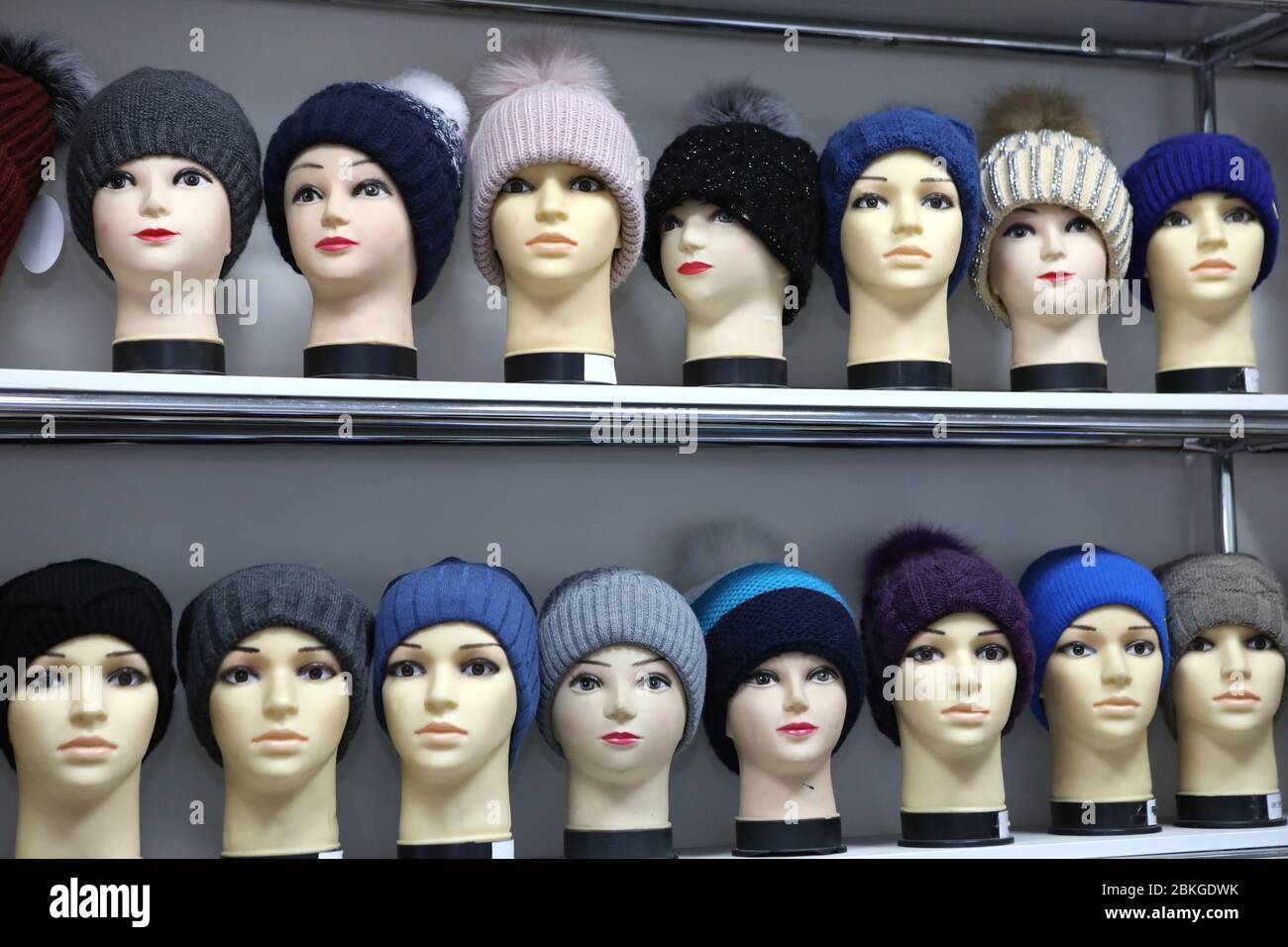 Mannequin heads in knitted hats and scarves. Mannequins female heads in ...