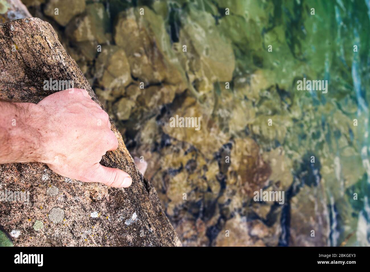 Mans hand on a rock with clean fresh water on background Stock Photo ...