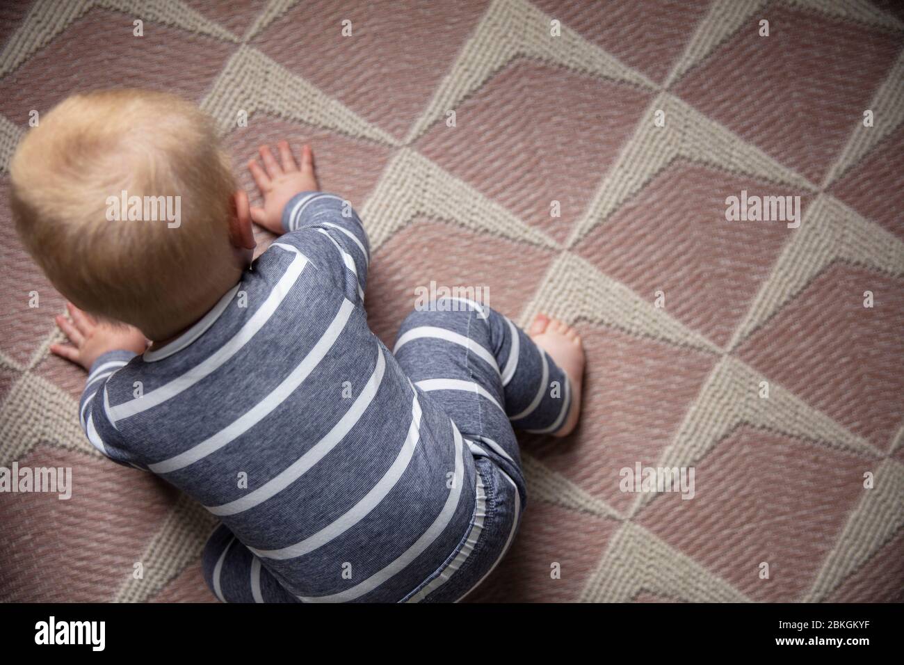 A young baby crawling. Overhead lifestyle baby development Stock Photo ...