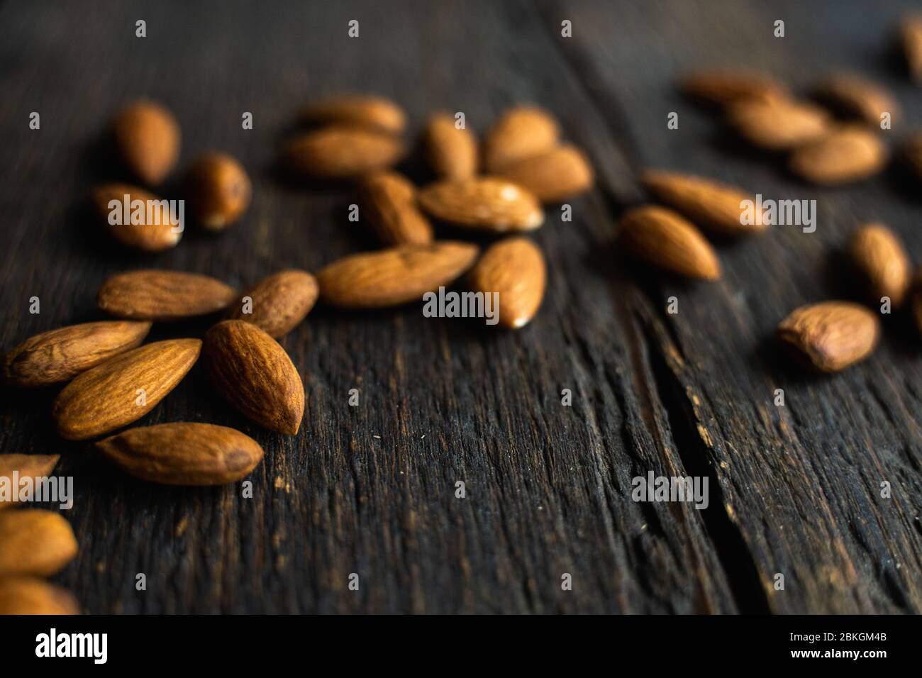 Almonds scattered on the wooden vintage table. Almond is a healthy ...