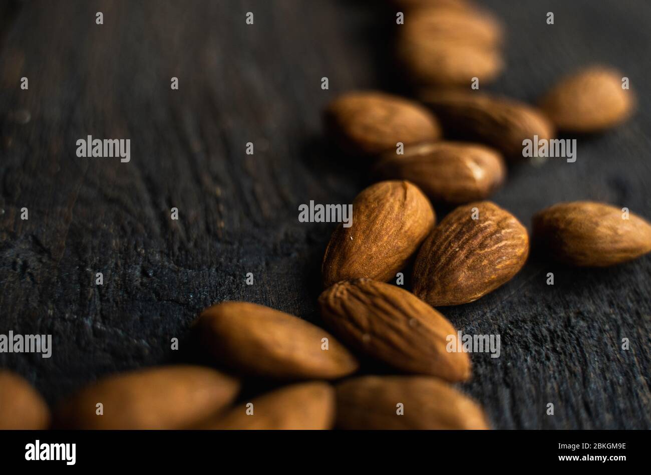 Almonds scattered on the wooden vintage table. Almond is a healthy ...