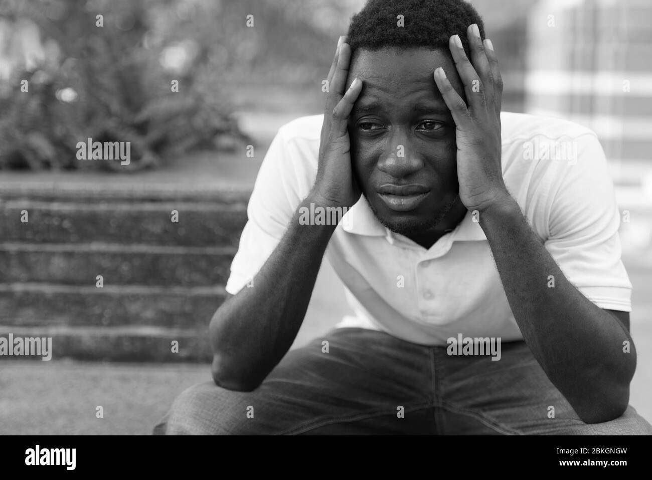 Portrait of stressed young African man looking upset while sitting ...