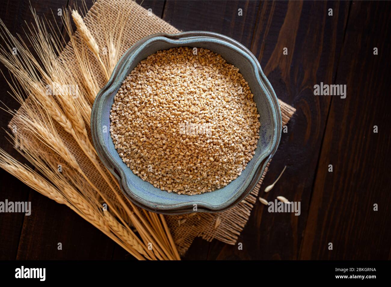 Overhead view of steel cut oats in a small bowl on a wooden surface ...