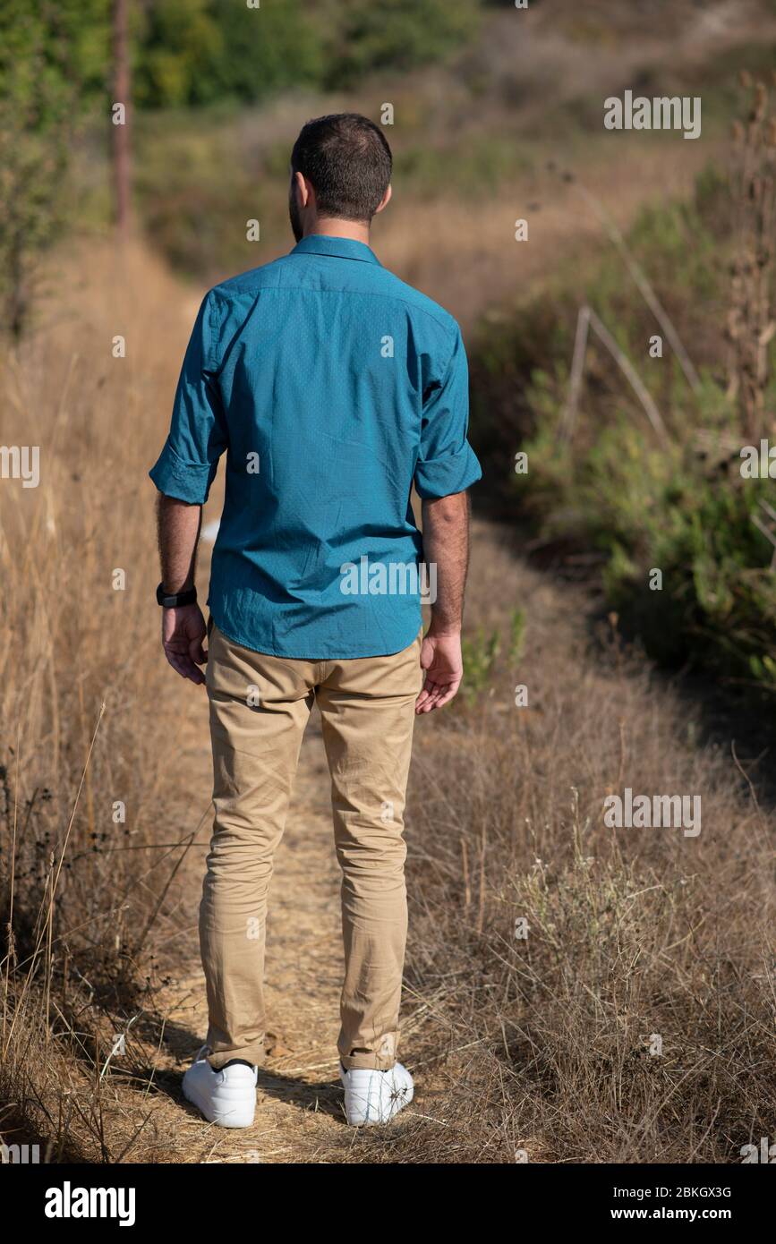 Rear view of young man in the countryside Stock Photo - Alamy
