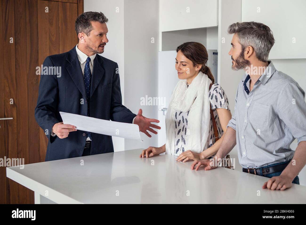 Real estate agent talking to couple Stock Photo - Alamy