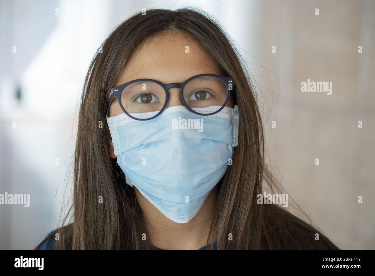 Close up of teenage girl wearing blue surgical mask Stock Photo - Alamy