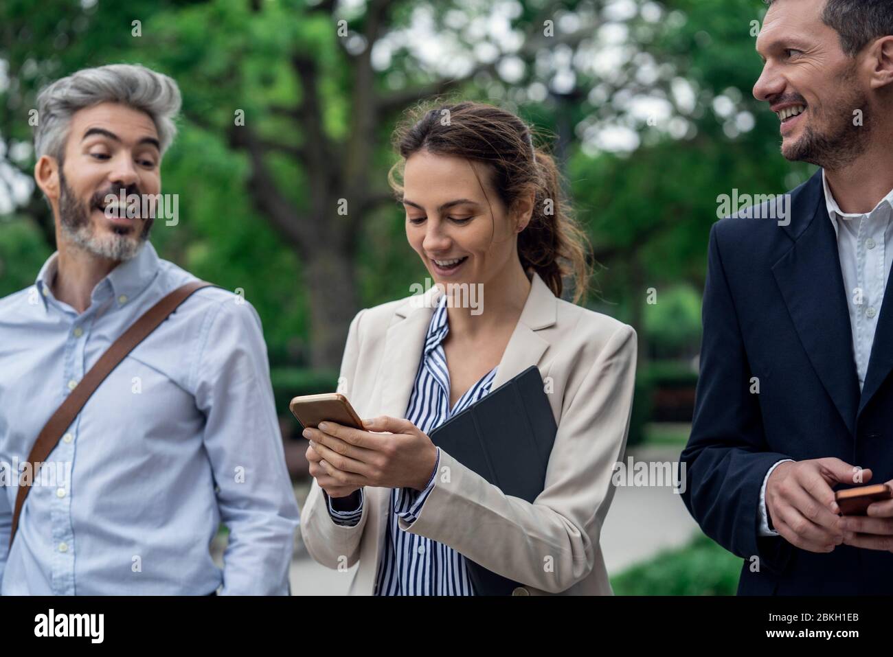 Business people using smartphones in public park Stock Photo - Alamy