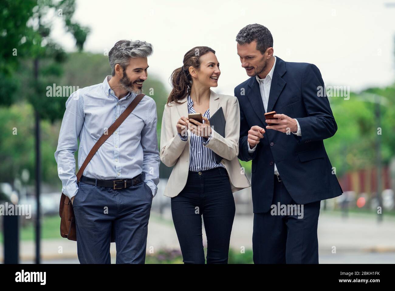 Business people using smartphones in public park Stock Photo - Alamy