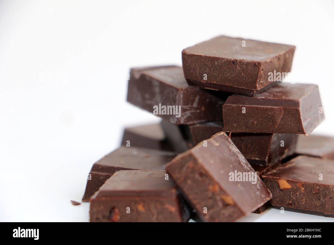 broken up chocolate pieces in a small pile isolated on a white ...
