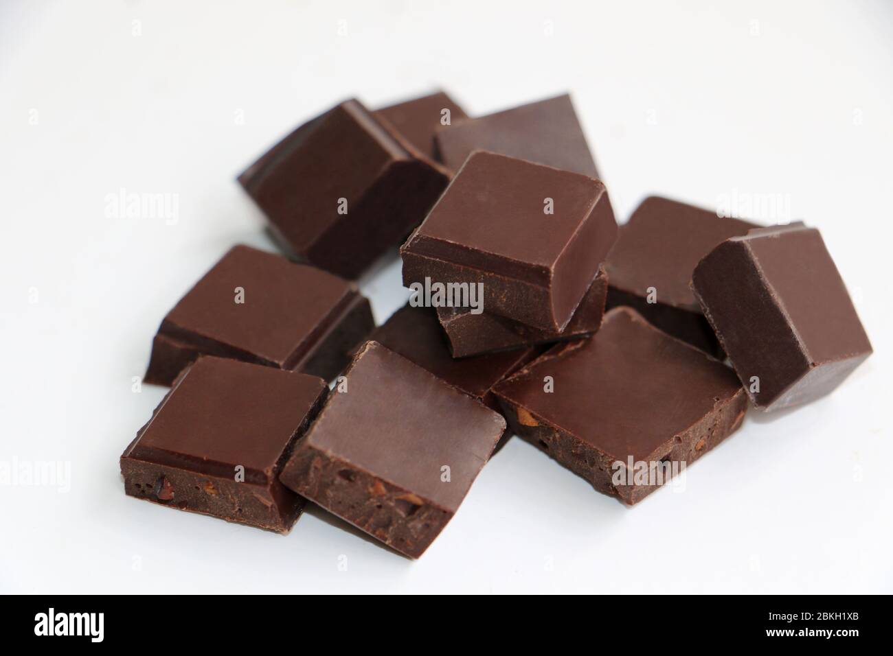 broken up chocolate pieces in a small pile isolated on a white ...