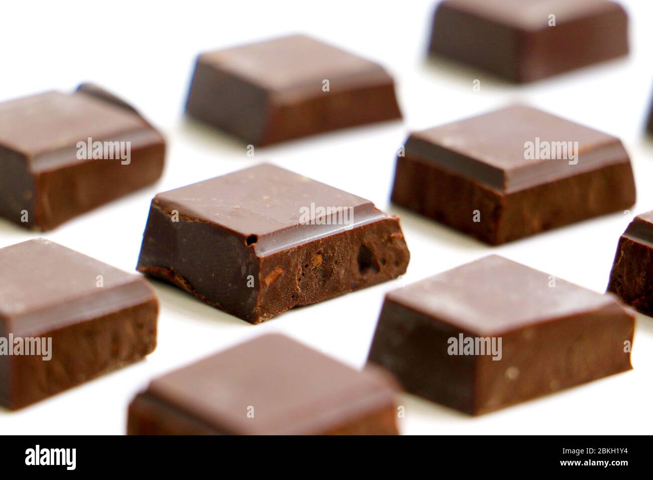 broken up chocolate pieces in a small pile isolated on a white ...